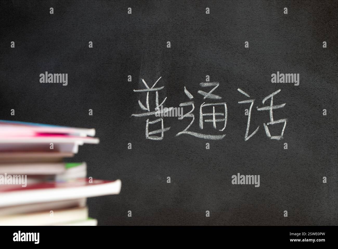 Hand writing on a blackboard in a Chinese language class with the word ...