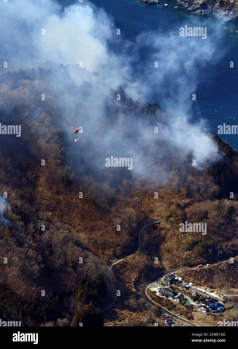 An aerial photo shows a forest fire, continues to spread in Ofunato ...