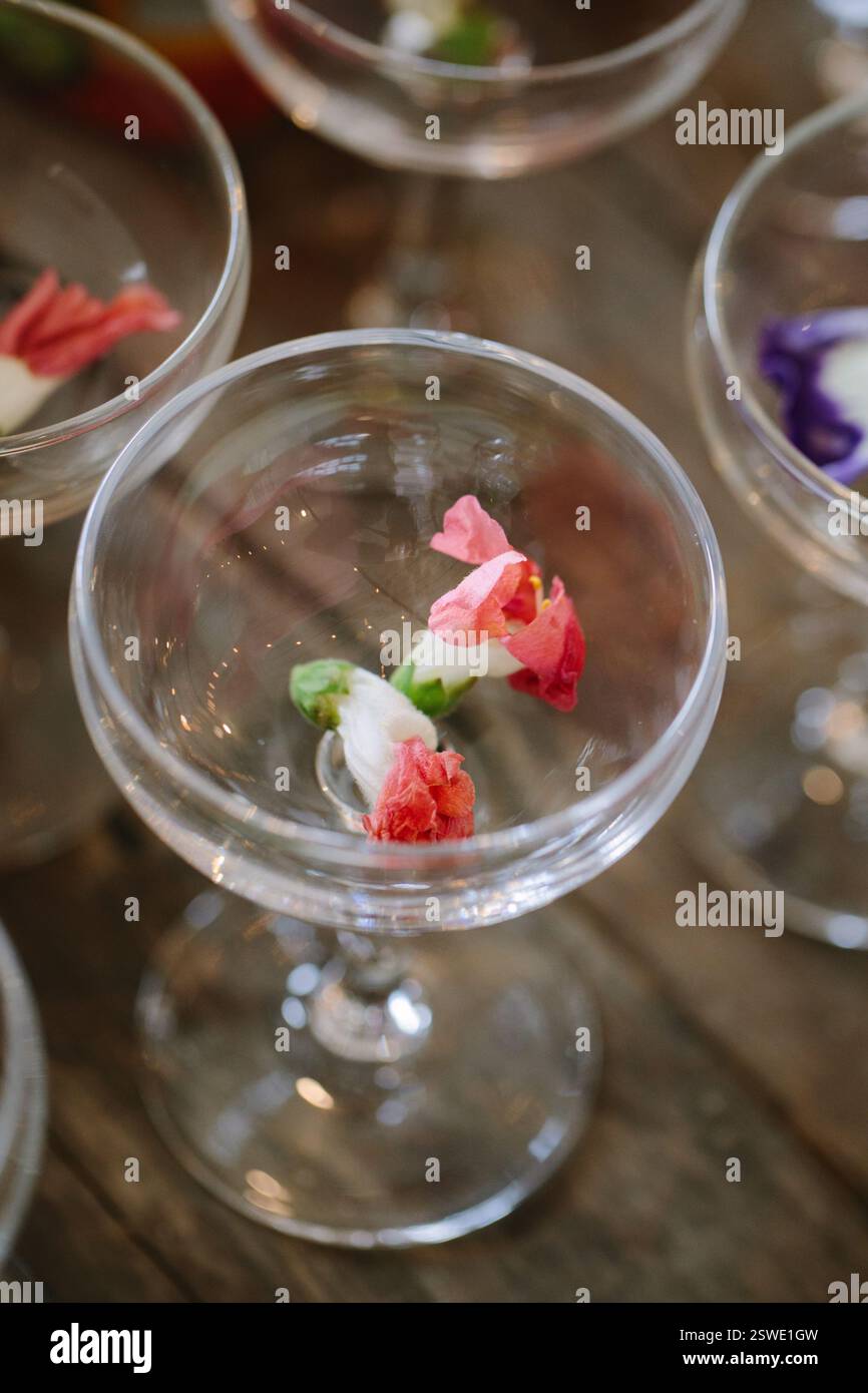 Delicate edible flowers rest in glass dessert cups, showcasing vibrant ...