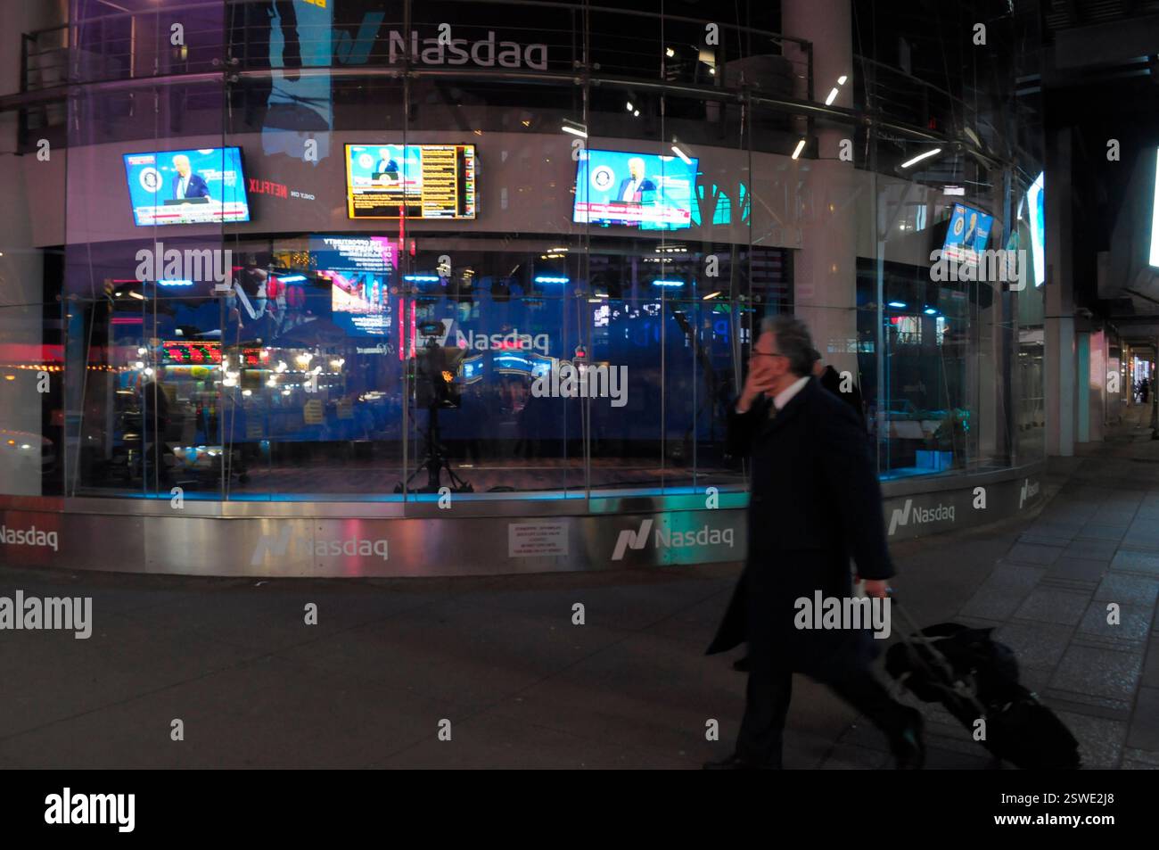 New York, United States. 19th Feb, 2025. People walk past the Nasdaq ...
