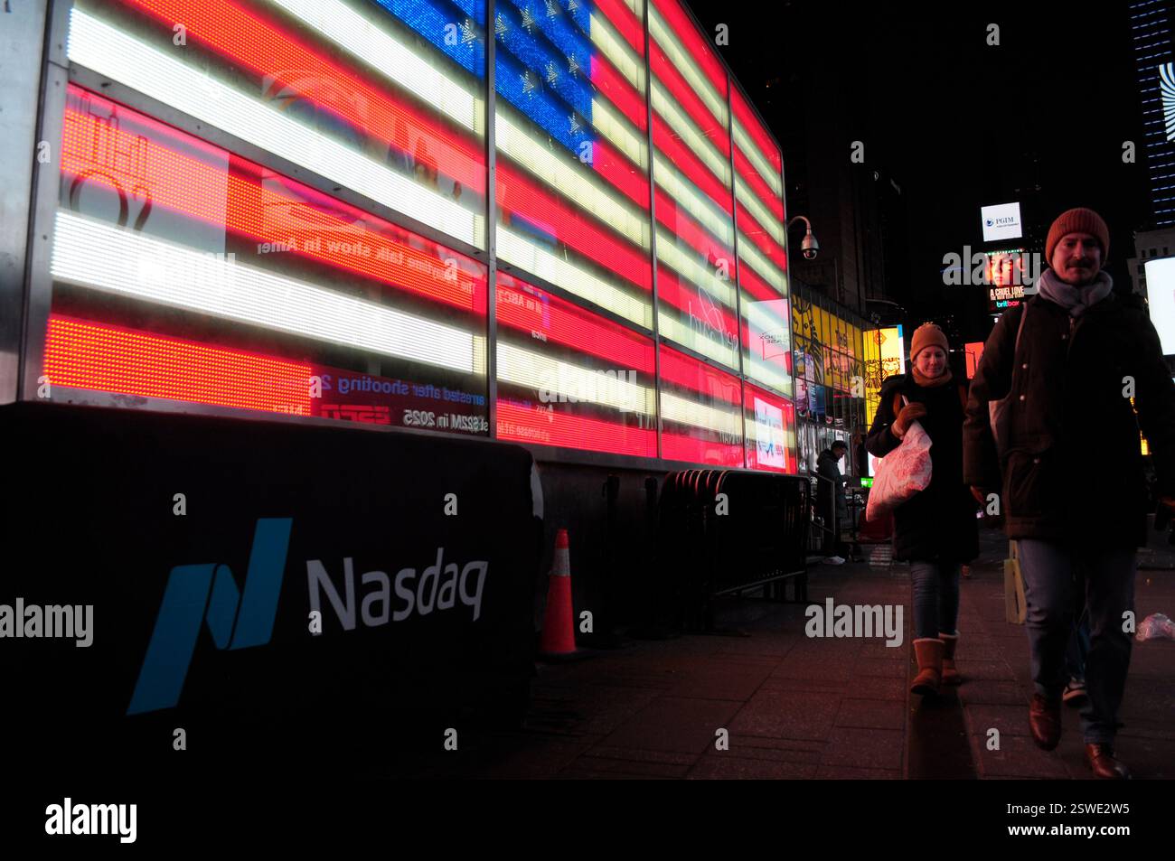 New York, United States. 19th Feb, 2025. People walk past a Nasdaq sign ...