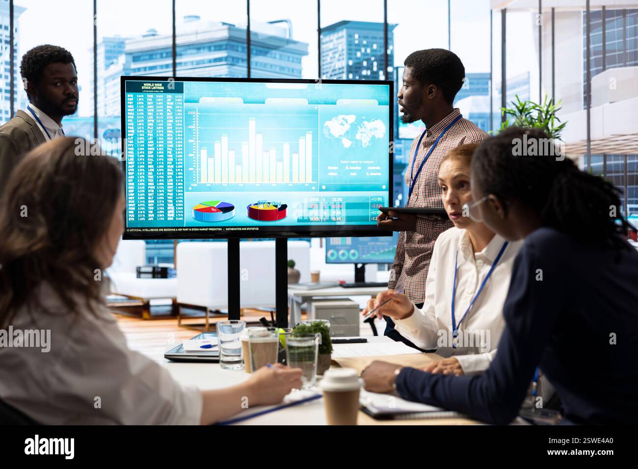 Team of workers presenting infographics and sales numbers on an ...