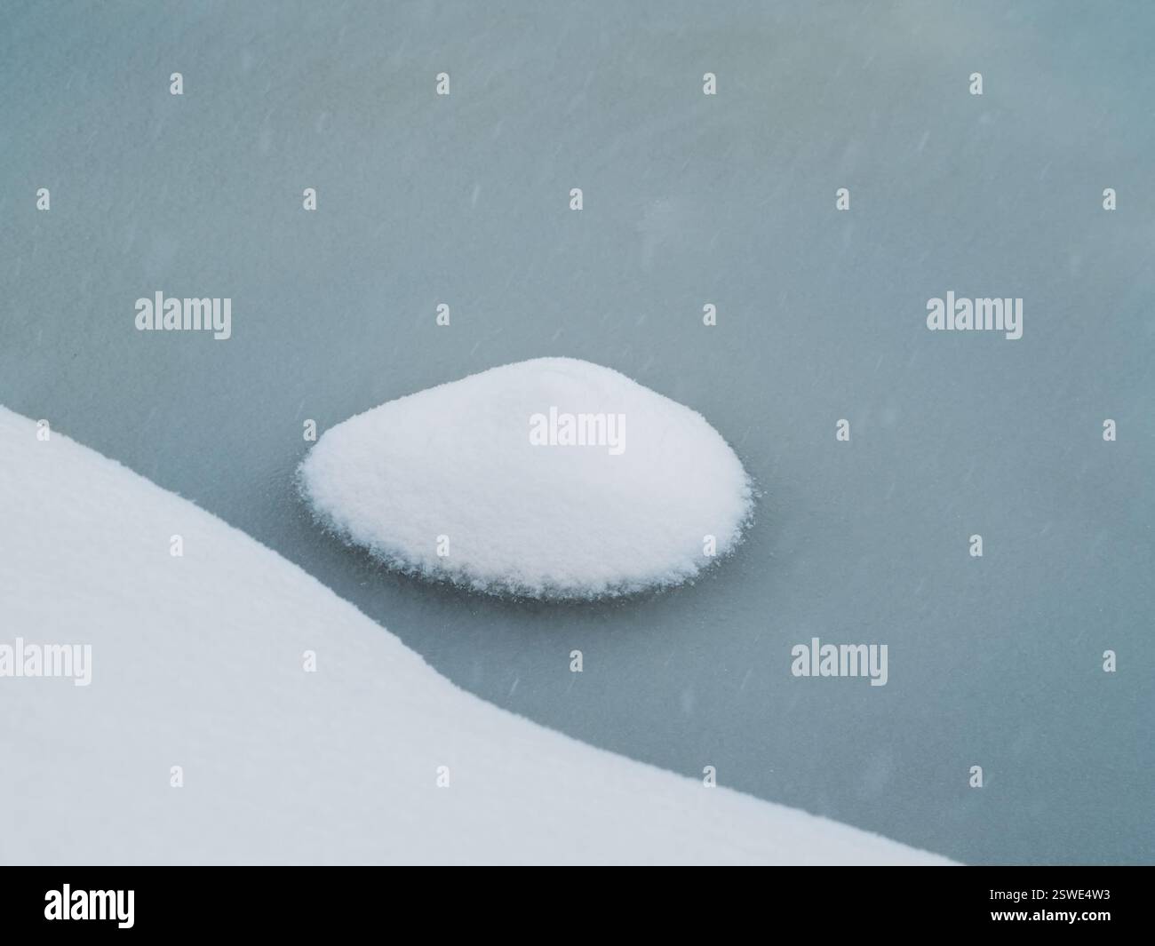Selective focus. Spring ice, small snowy round island on melting ice ...