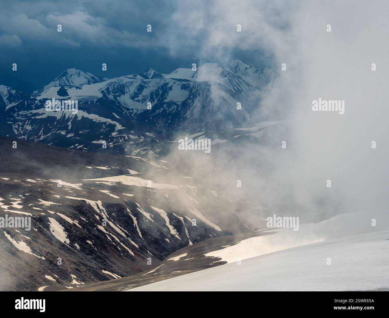 Storm on the top of a mountain. Wonderful dramatic landscape with big snowy mountain peaks above ...