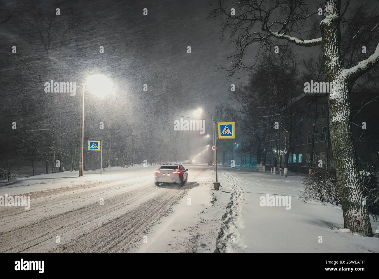 Night snowfall on a city street. A strong blizzard on the highwa Stock ...