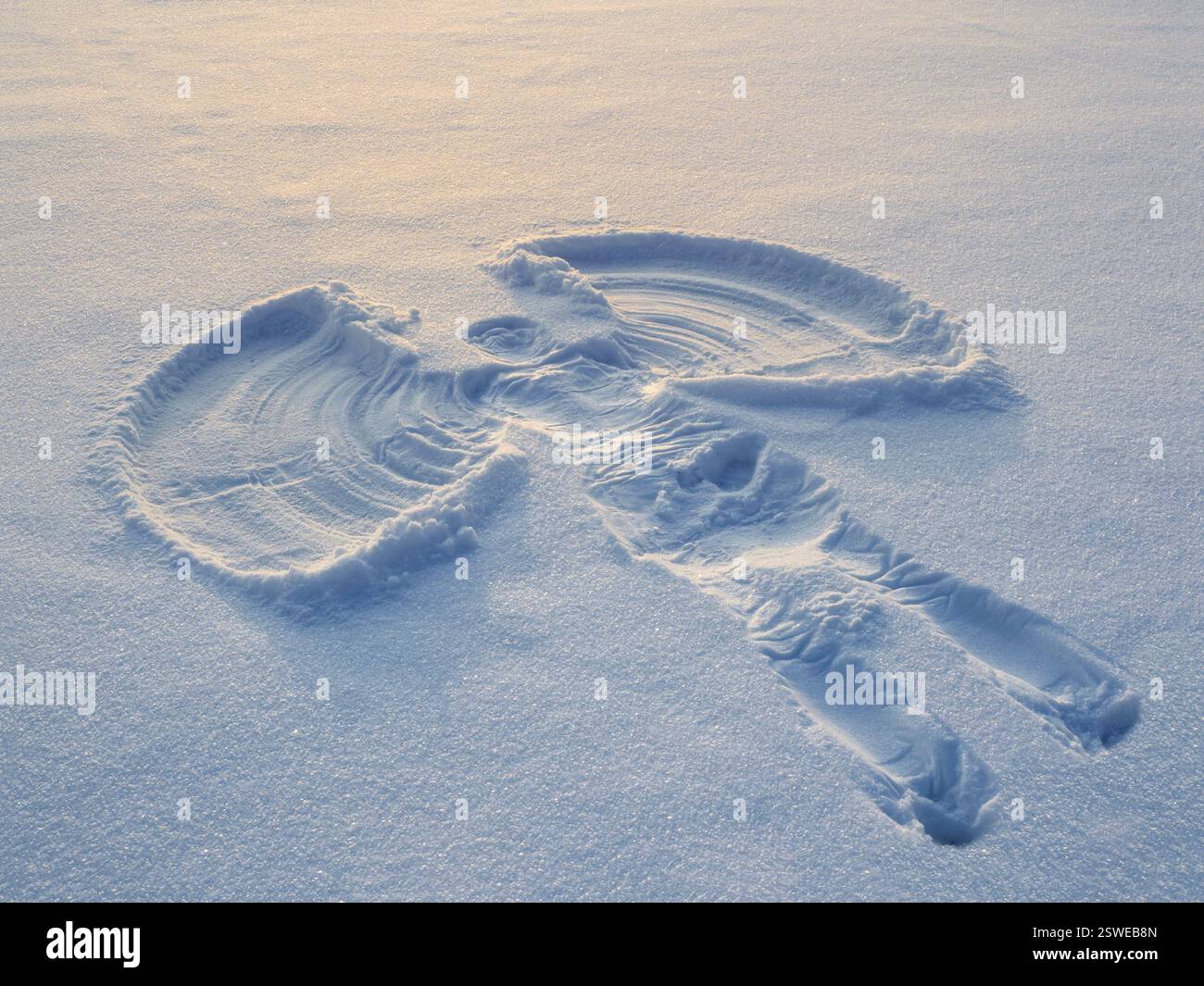 Snow angel made in the white snow in the evening. Top flat overhead ...