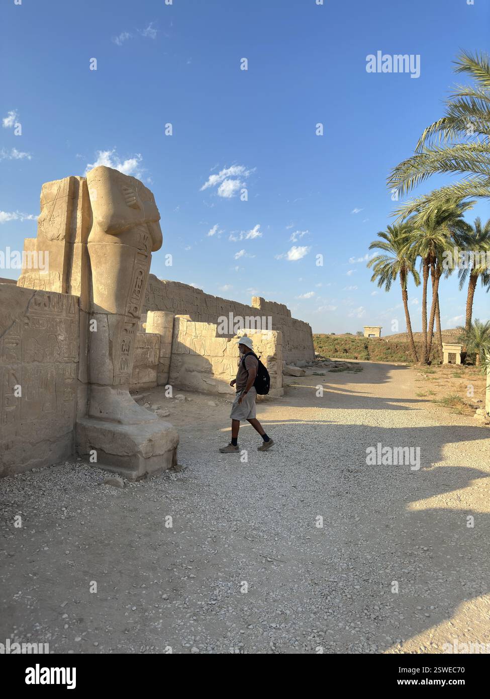 Luxor, Egypt - October 22, 2023: A man and headless colossal statue at ...