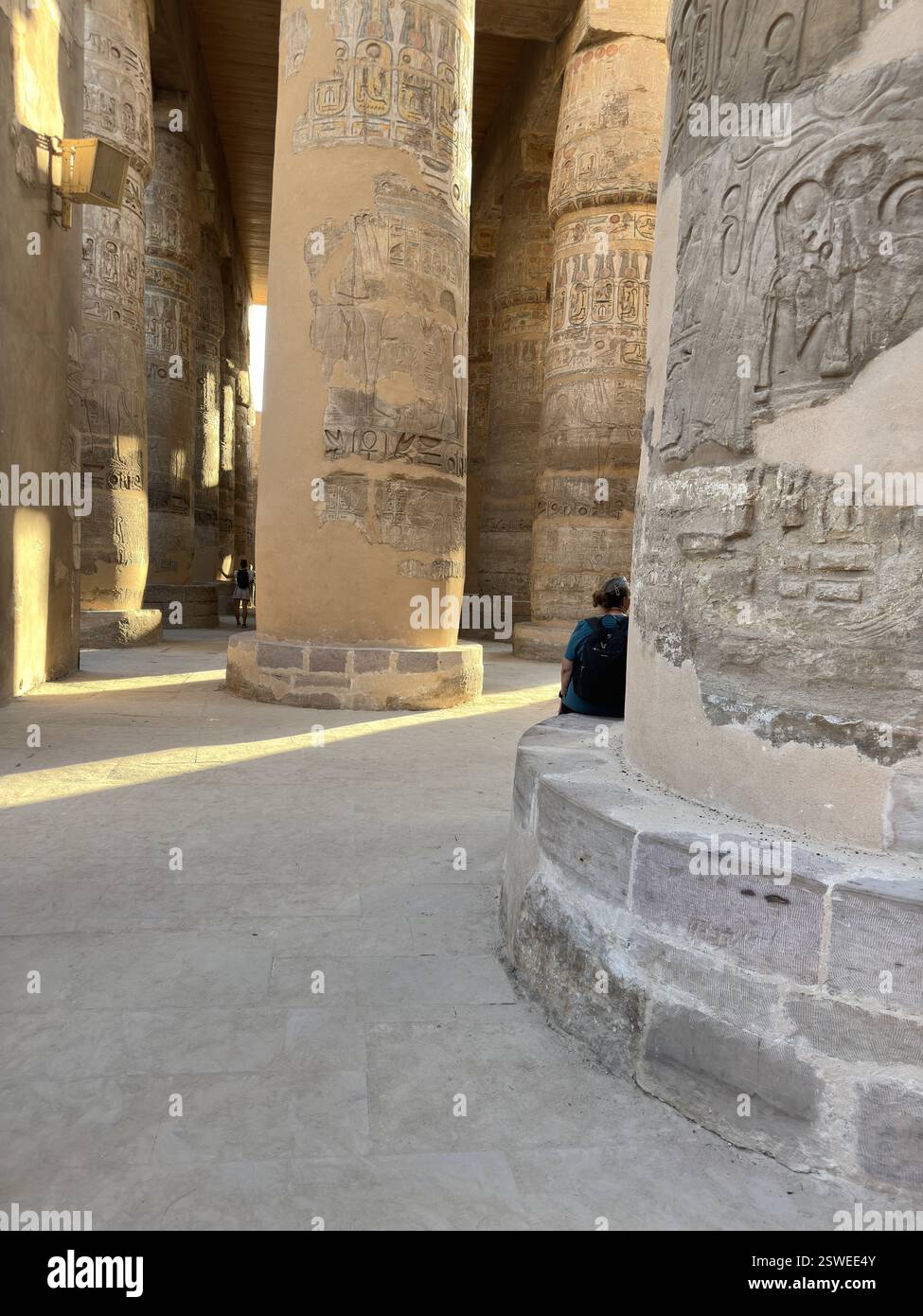 Tourists between the columns of Great Hypostyle Hall at Karnak Temple ...