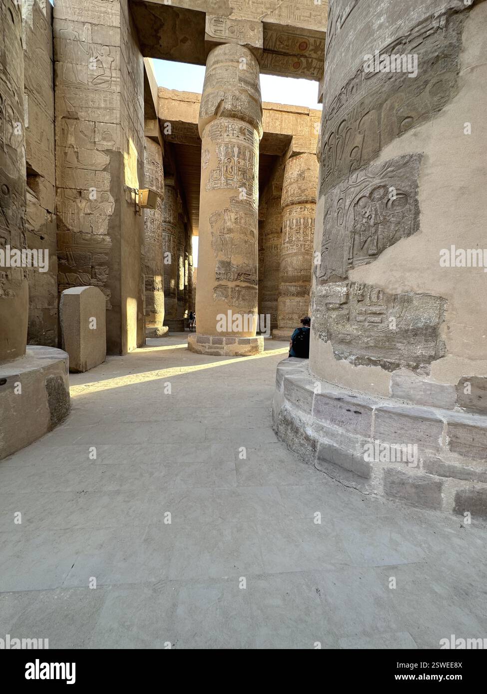 Tourists between the columns of Great Hypostyle Hall at Karnak Temple ...
