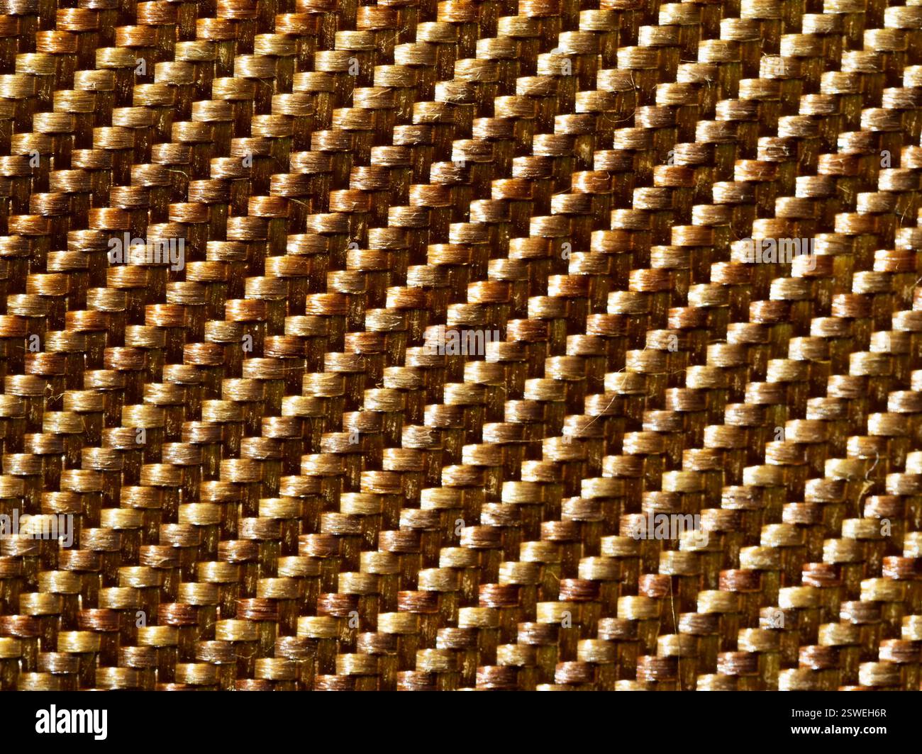Close up bulletproof material aramid. Aramid kevlar background. Golden ...