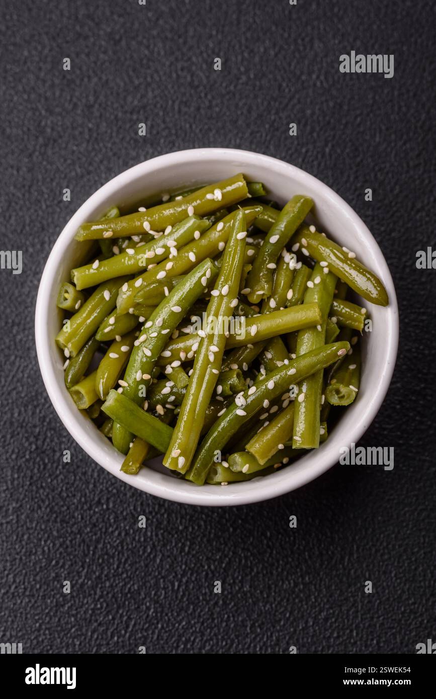 Steamed green beans on a plate with olive oil, sesame seeds, salt and ...