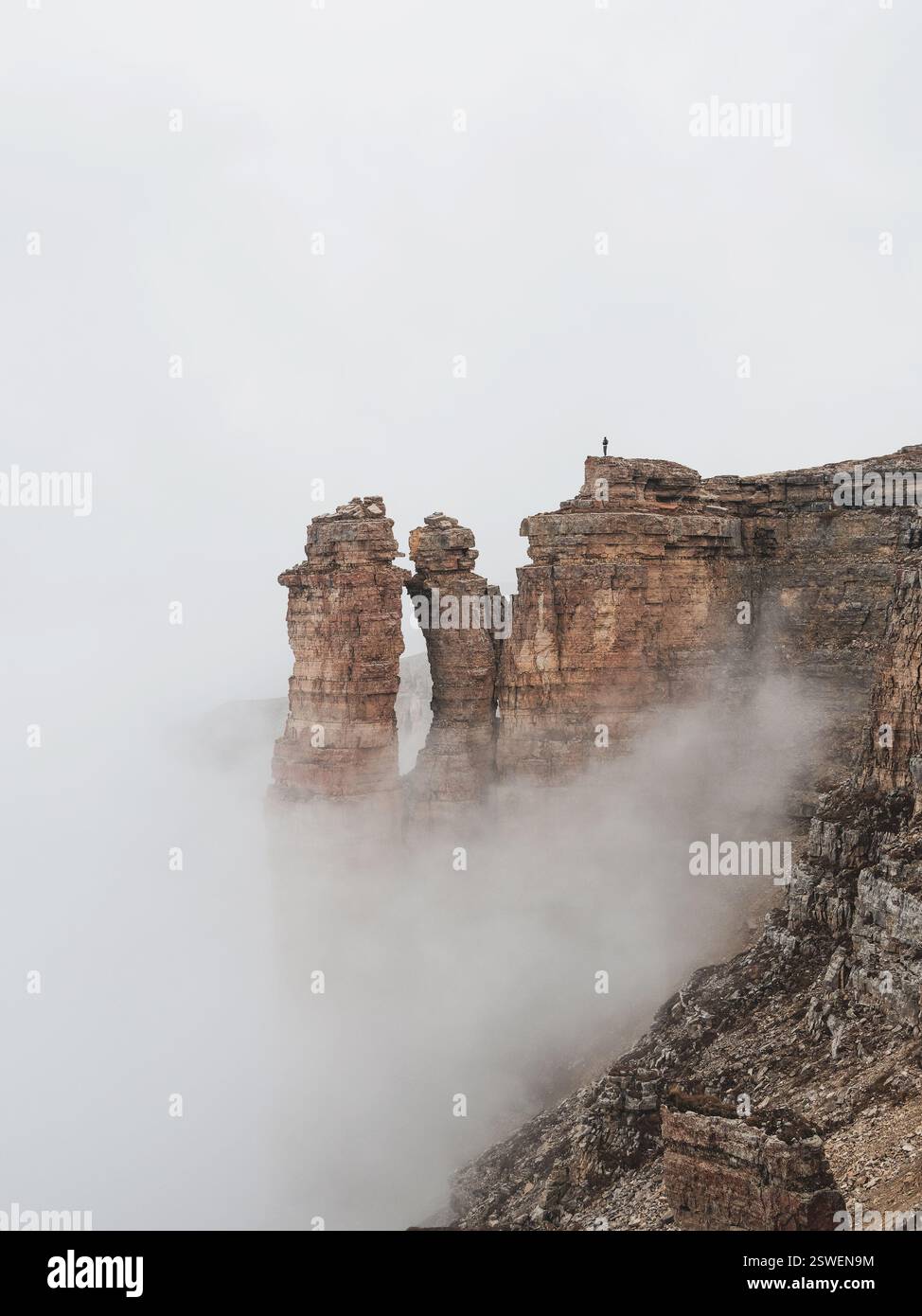 Vertical view of sharp rocks in the fog. Mountains in a dense fog ...