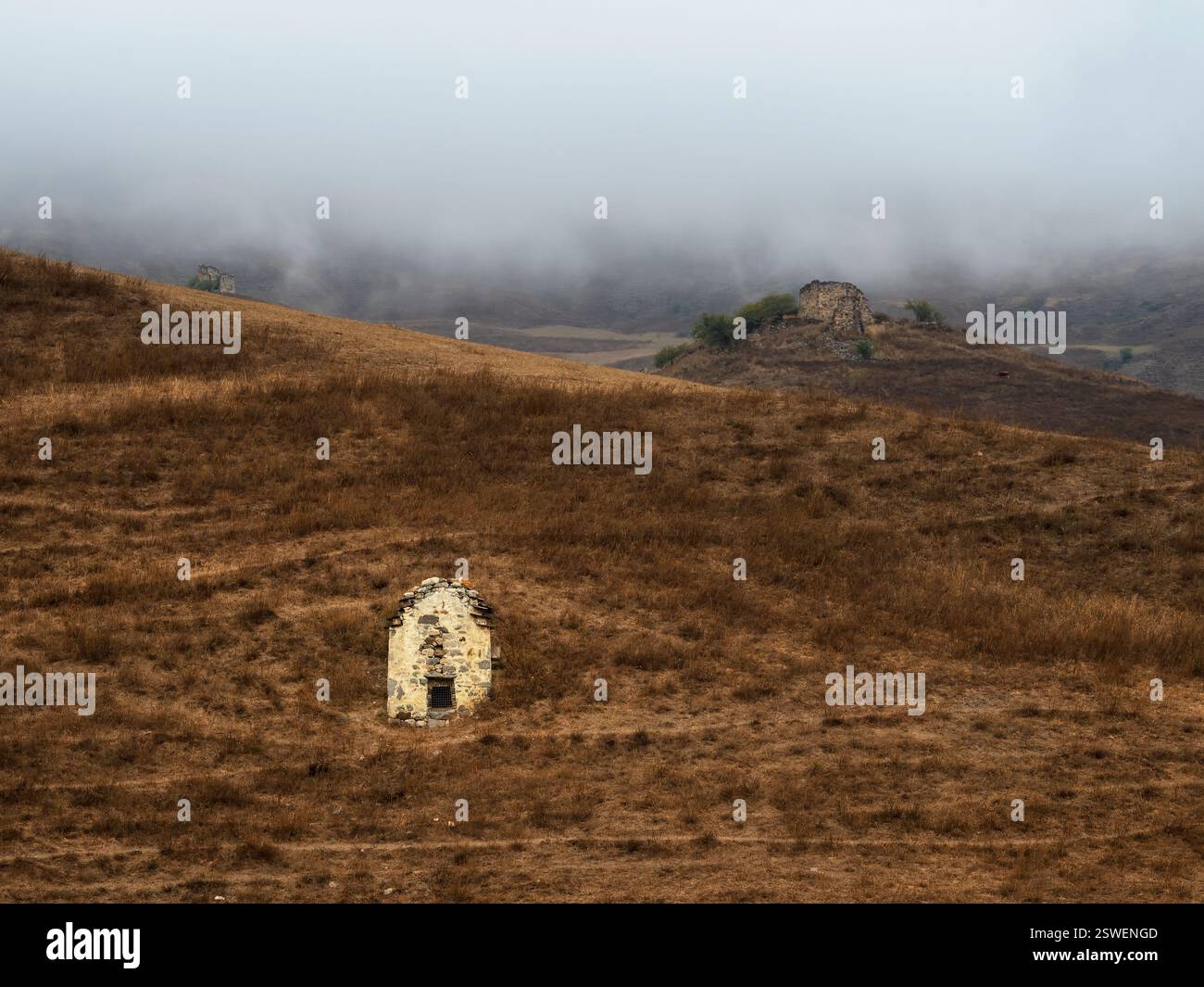 Misty view of old family crypt on a misty mountain slope. Old Erzi ...