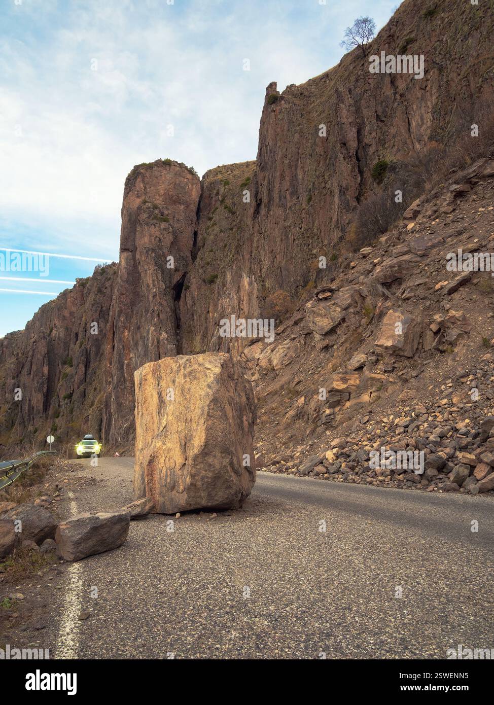 Vertical view of large granite boulder fell on the road. Dangerous ...