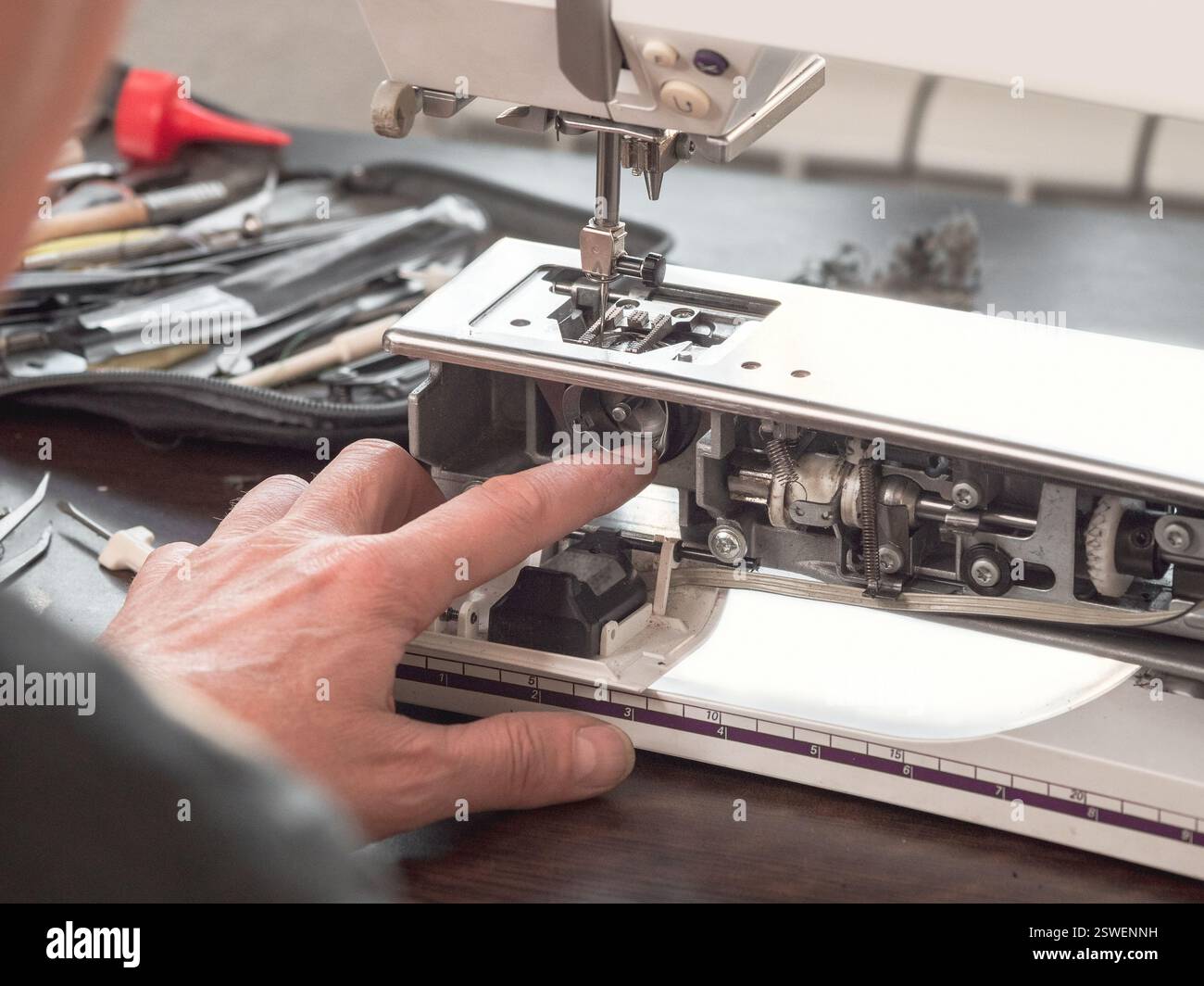 The finger of the sewing machine adjuster repairs the internal ...