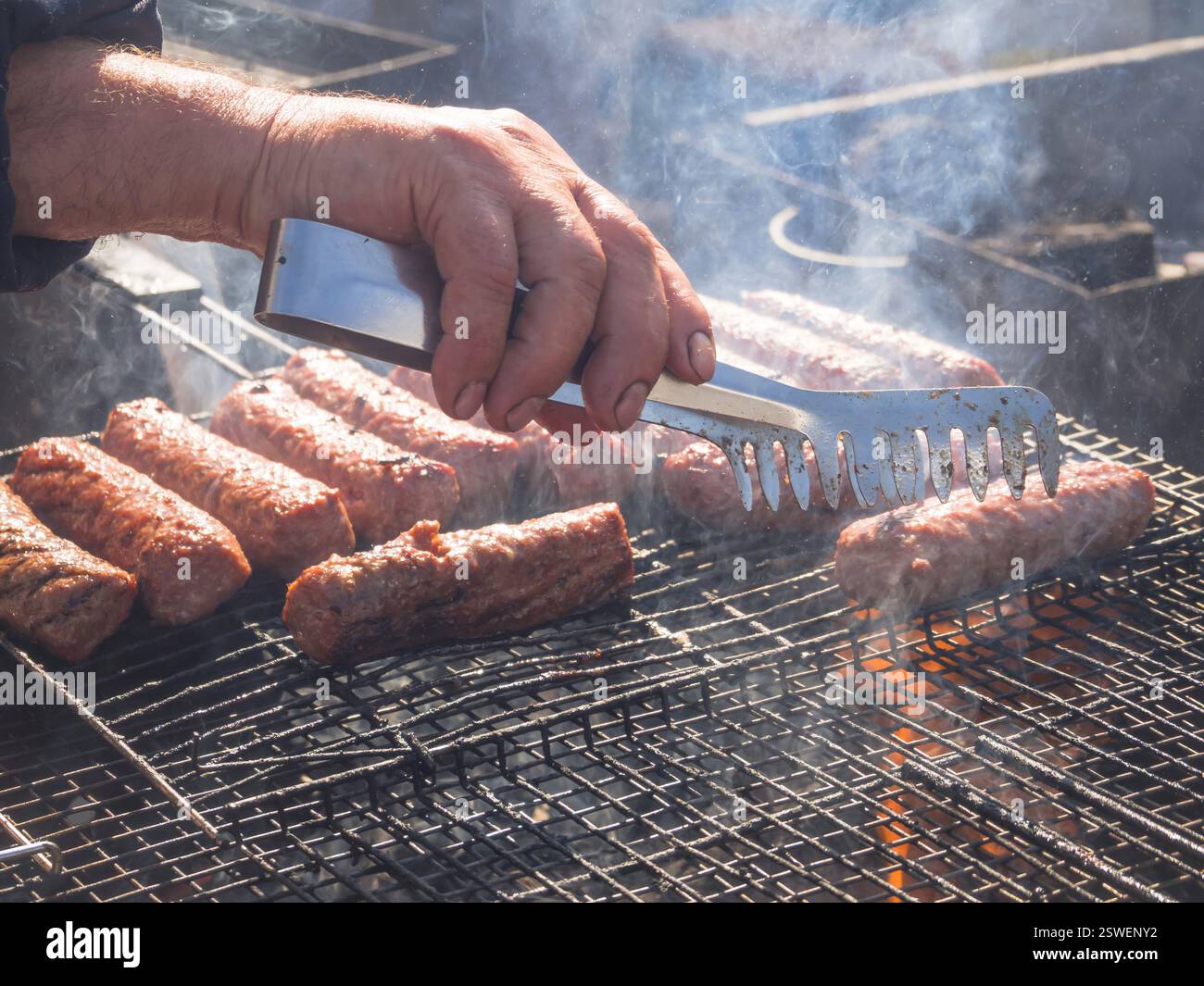 Cooking BBQ meat. Romanian mititei and cooked on the grill in the smoke ...