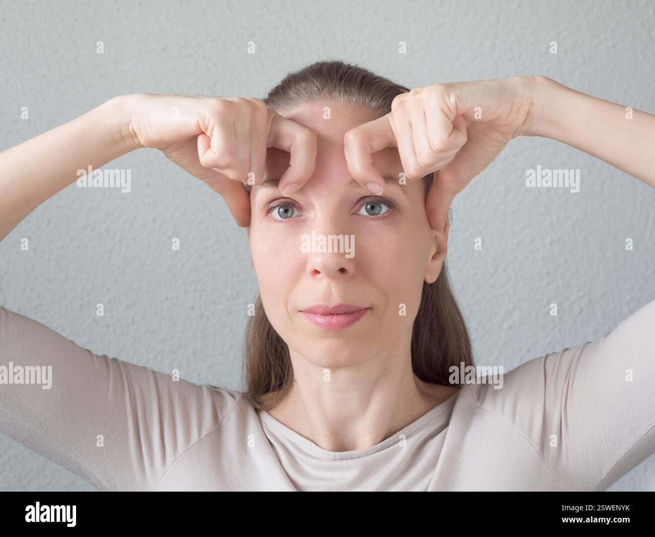 Gymnastics for the face. Woman does rejuvenating exercises for the face ...
