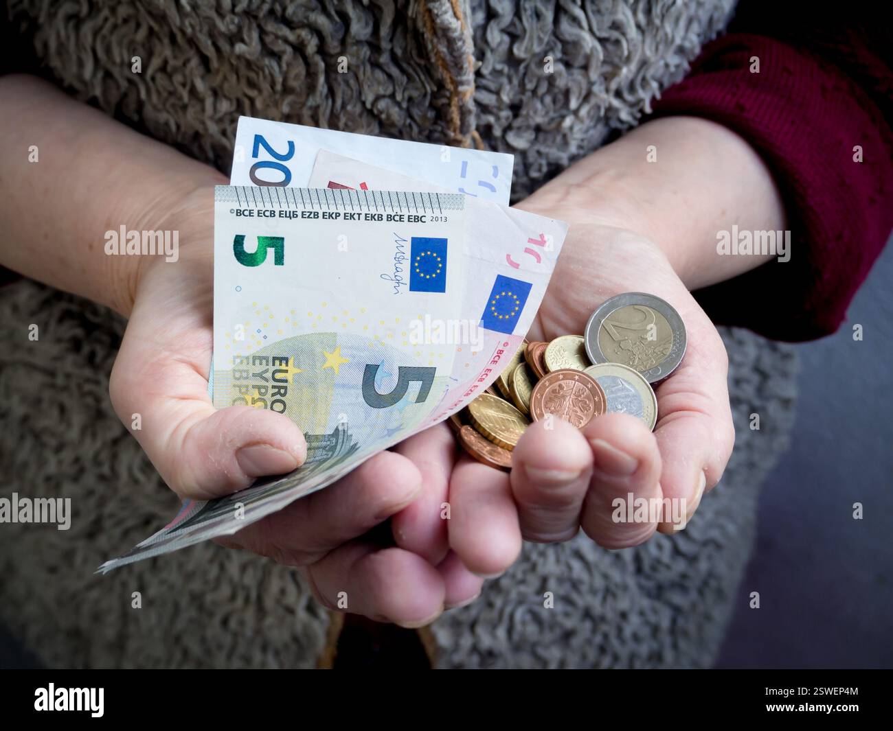 Retired with Euro coins in hand. The problem of poverty Stock Photo - Alamy