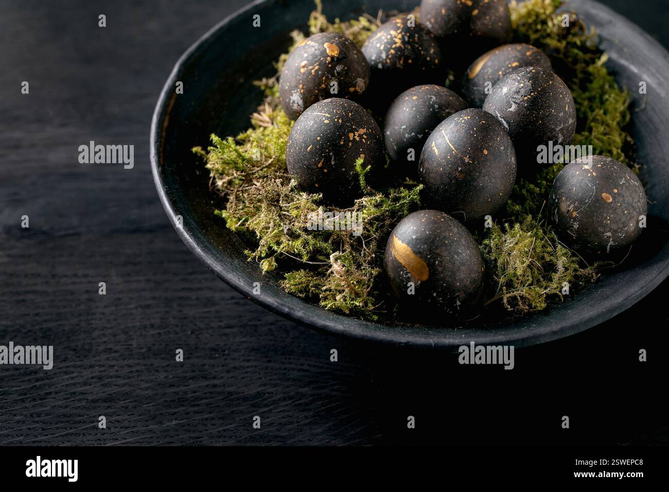 Bio colored black eggs with golden spots Stock Photo - Alamy