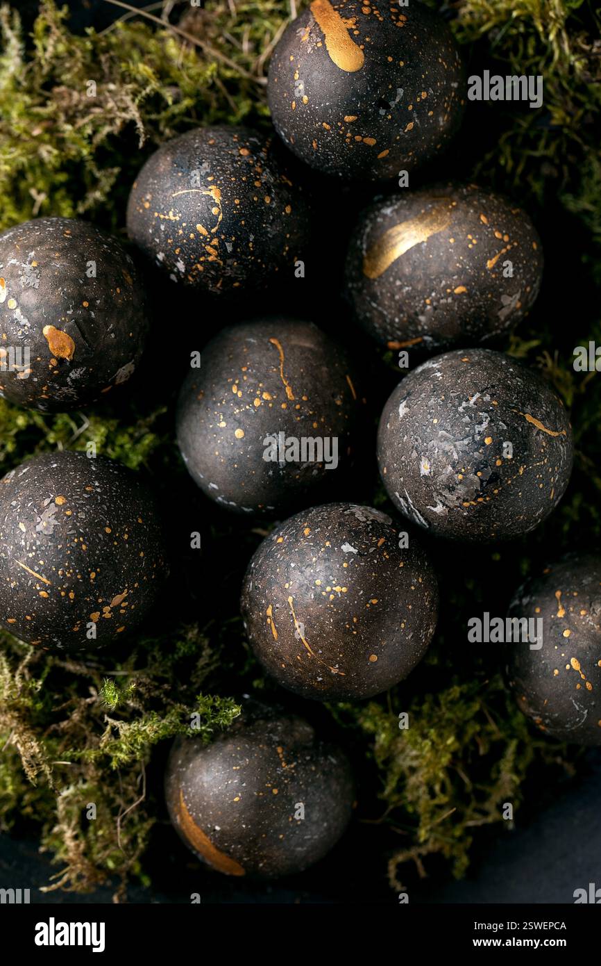 Bio colored black eggs with golden spots Stock Photo - Alamy