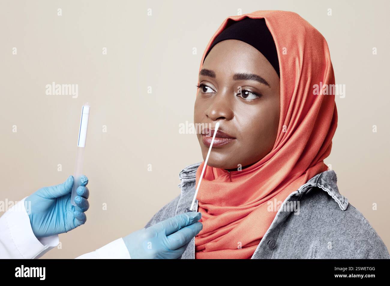 Medical worker taking swab for coronavirus sample from muslim woman ...