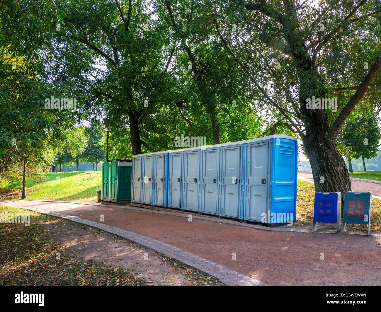 Portable washrooms in nature. Long row of portable bio toilet cabins in ...