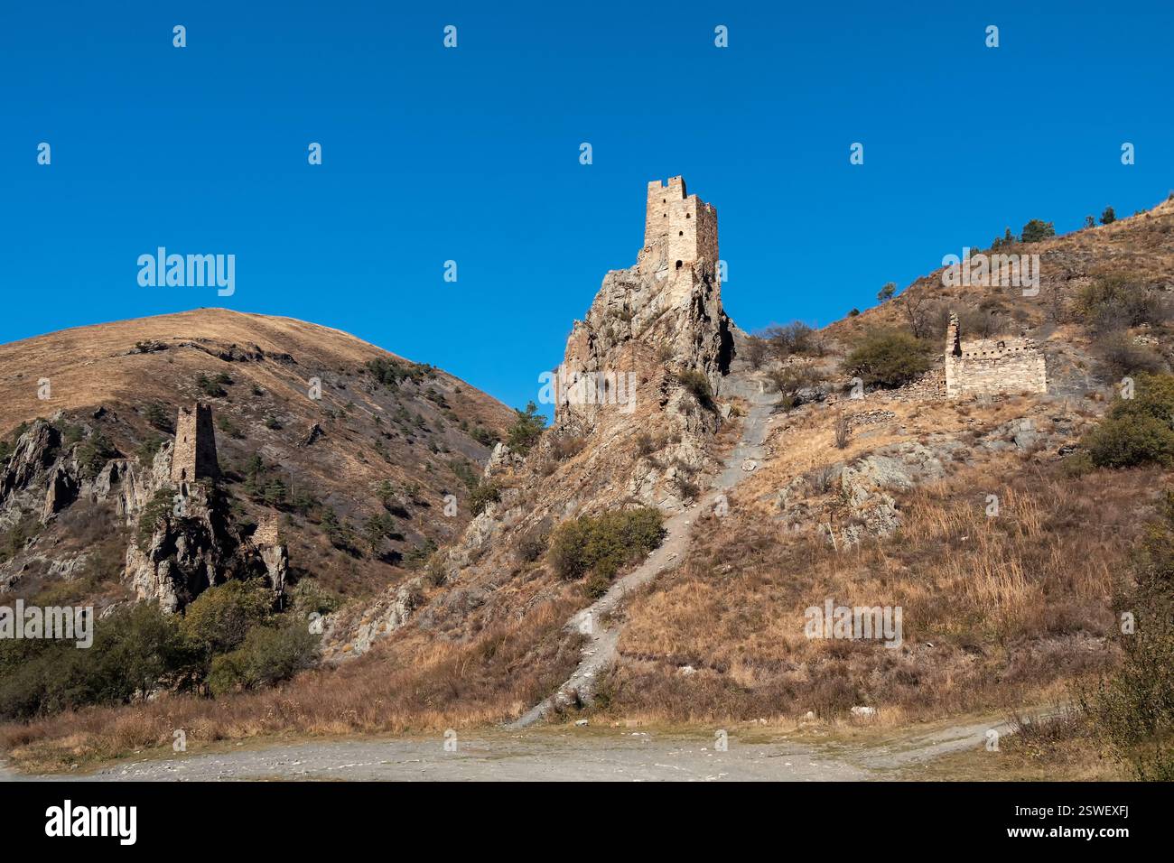 Sunny afternoon in the Caucasus mountains. Medieval tower complex ...