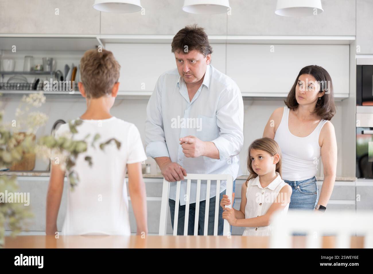 Preteen boy being scolded by angry parents in the kitchen Stock Photo ...