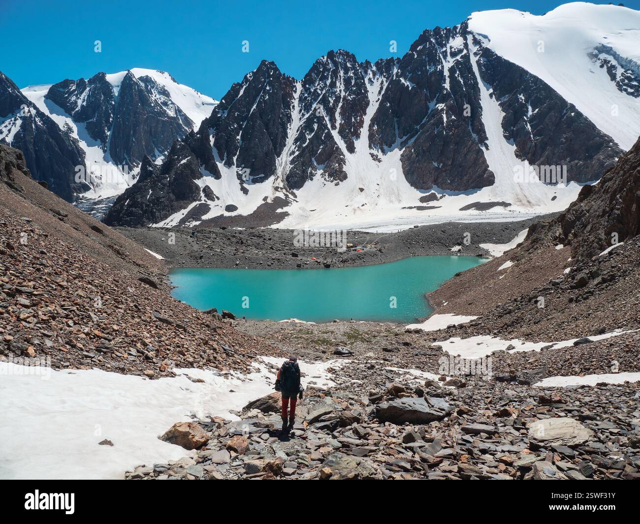 Difficult descent to the lake on sharp rocks. Solo hiking with a large ...