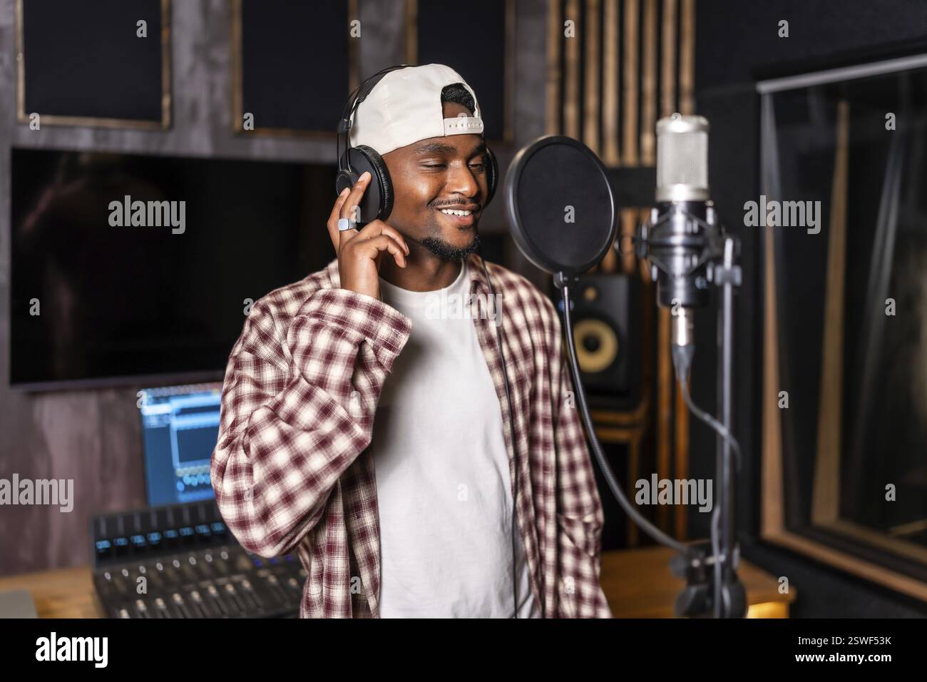 Young happy african american male singer wearing headphones and ...
