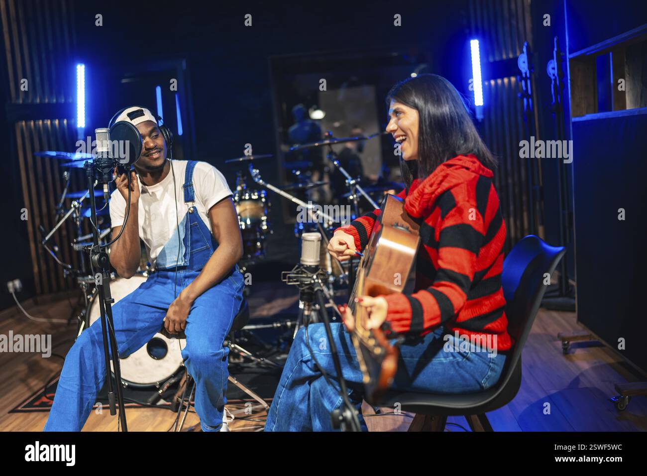 Male vocalist and a female guitarist are collaborating, recording music ...