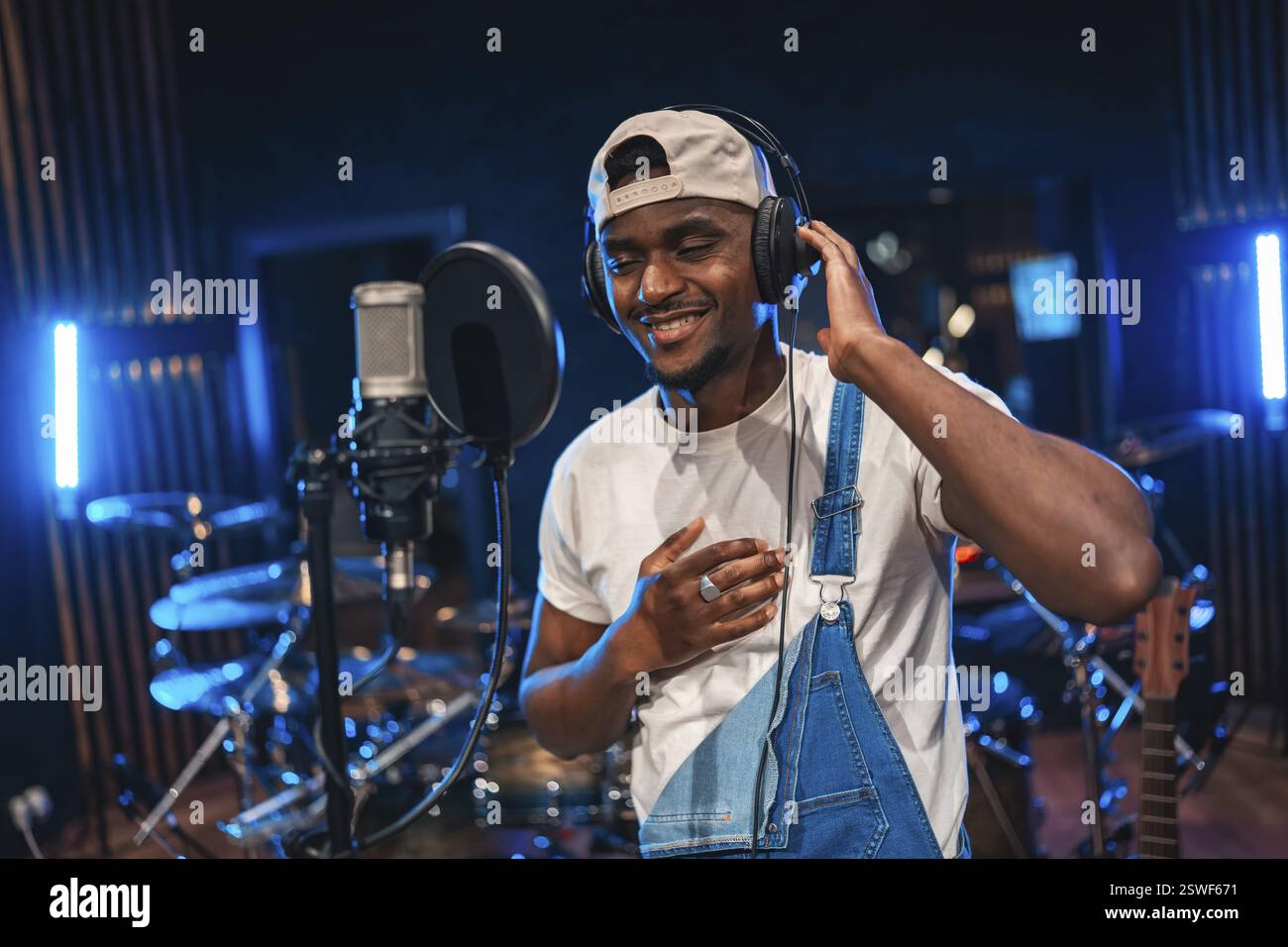 Young happy african american singer recording a song in professional ...