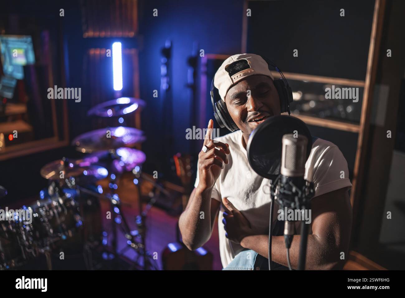 Young black man recording vocals for new album in professional music ...