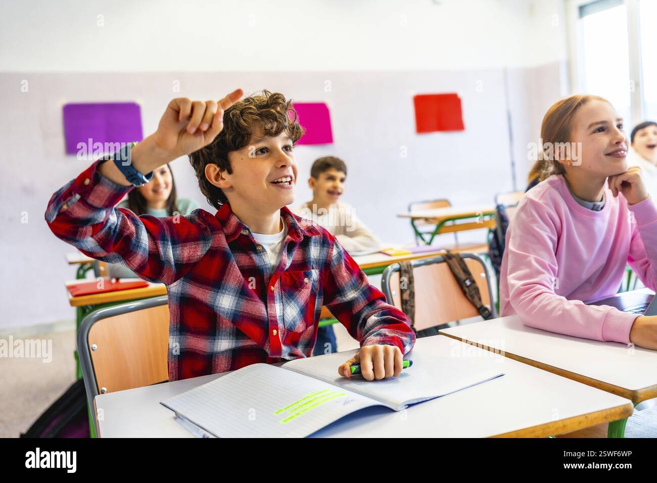 Elementary school student raising hand to answer a question during ...