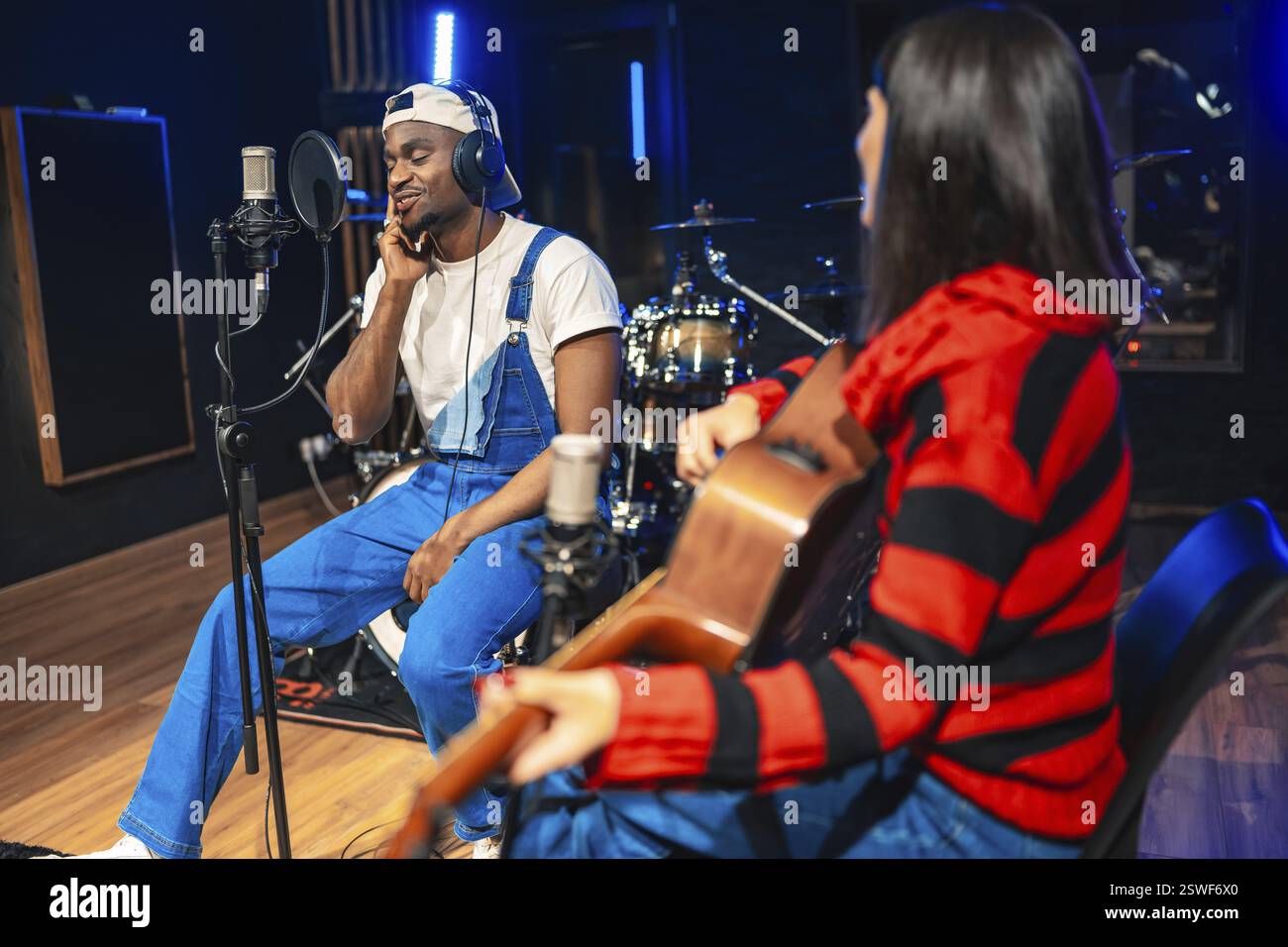 Two musicians collaborating in a professional recording studio, one ...