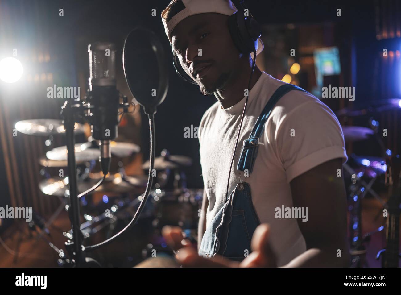 Young artist wearing headphones and singing or rapping in a ...