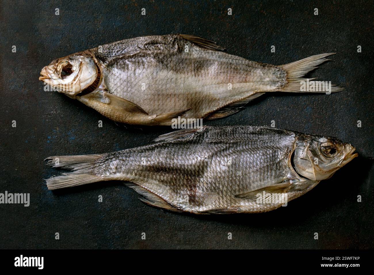 Heap dried sun-dried sea fish sea bream on dark textured background ...
