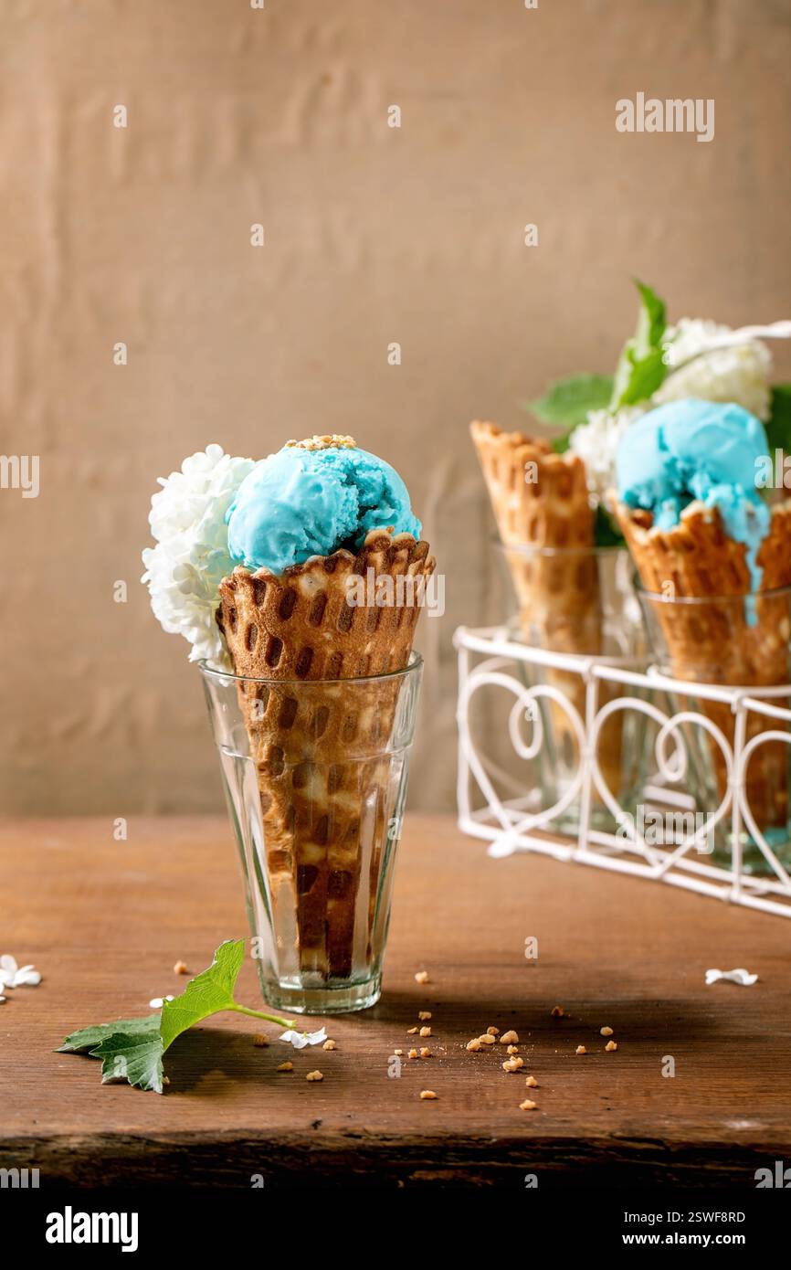 Turquoise ice cream with white flowers in waffle cones hi-res stock ...