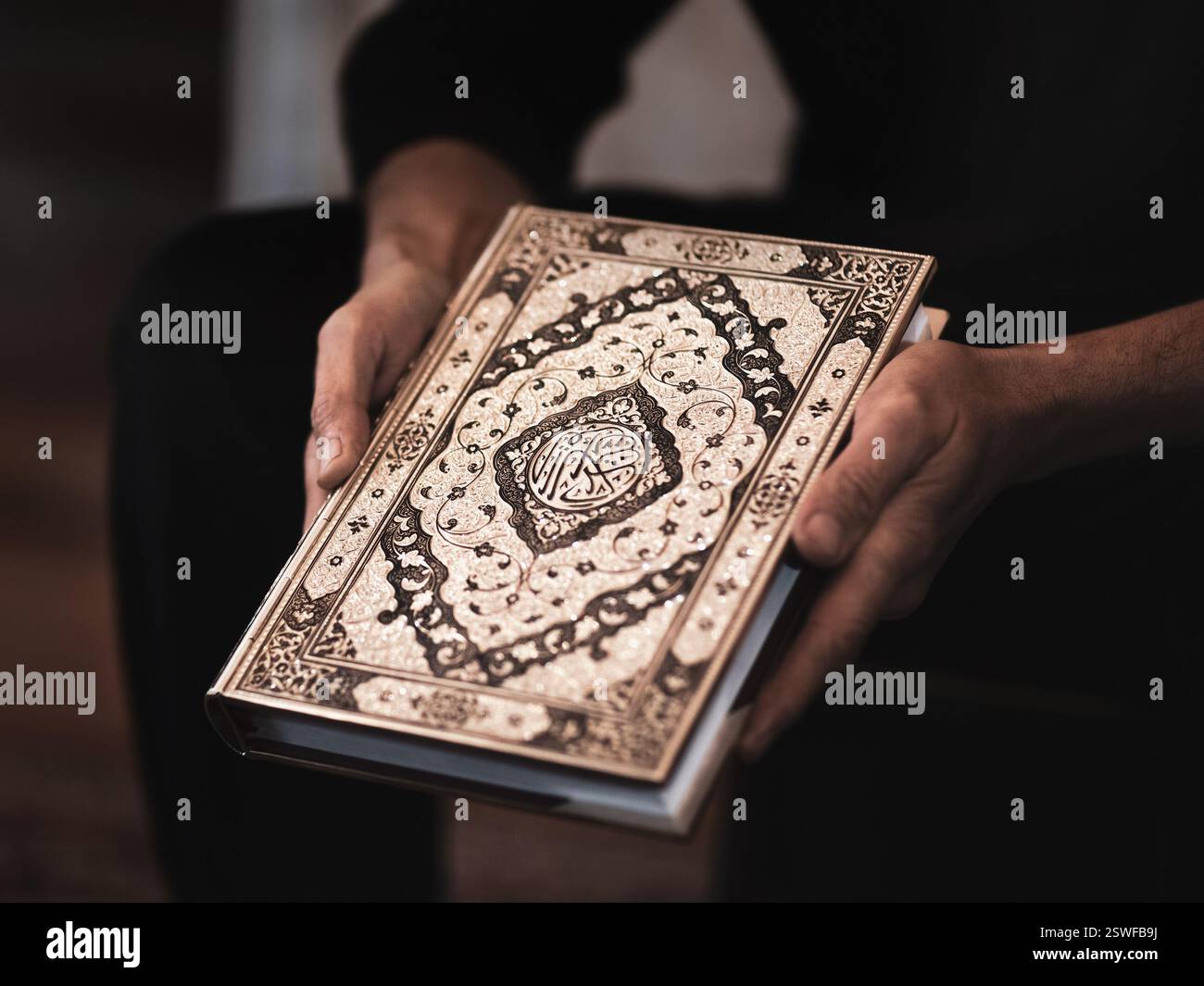 Quran - holy books of Muslims in hands Stock Photo - Alamy