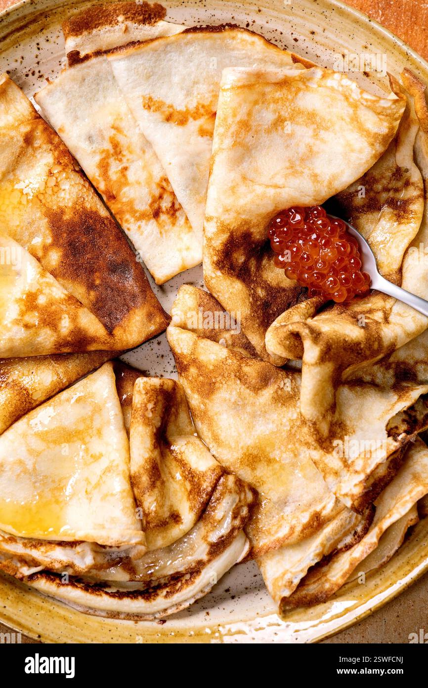 Thin pansakes with red caviar and butter Stock Photo - Alamy