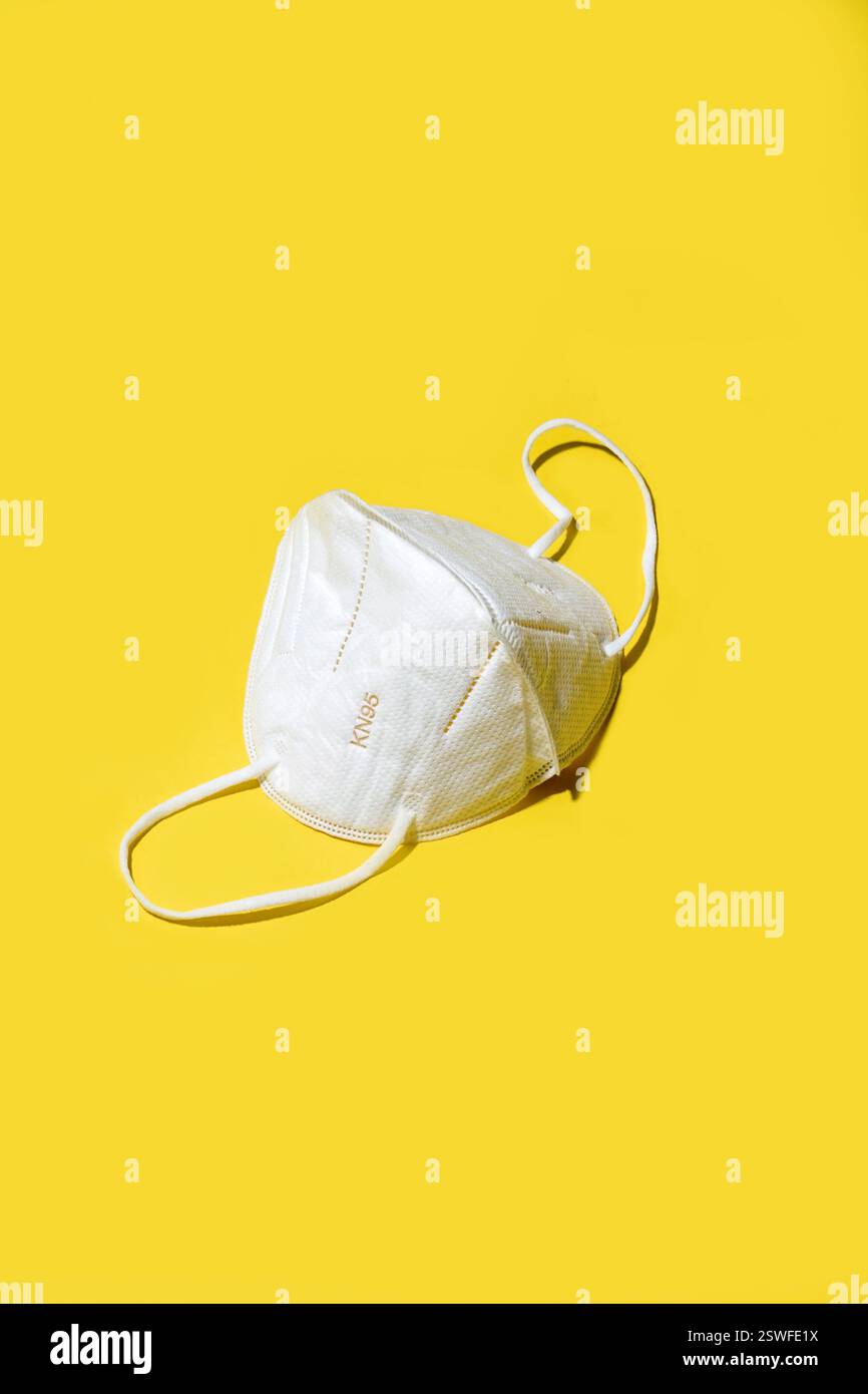 White medicine respirator KN95 mask over yellow Stock Photo - Alamy