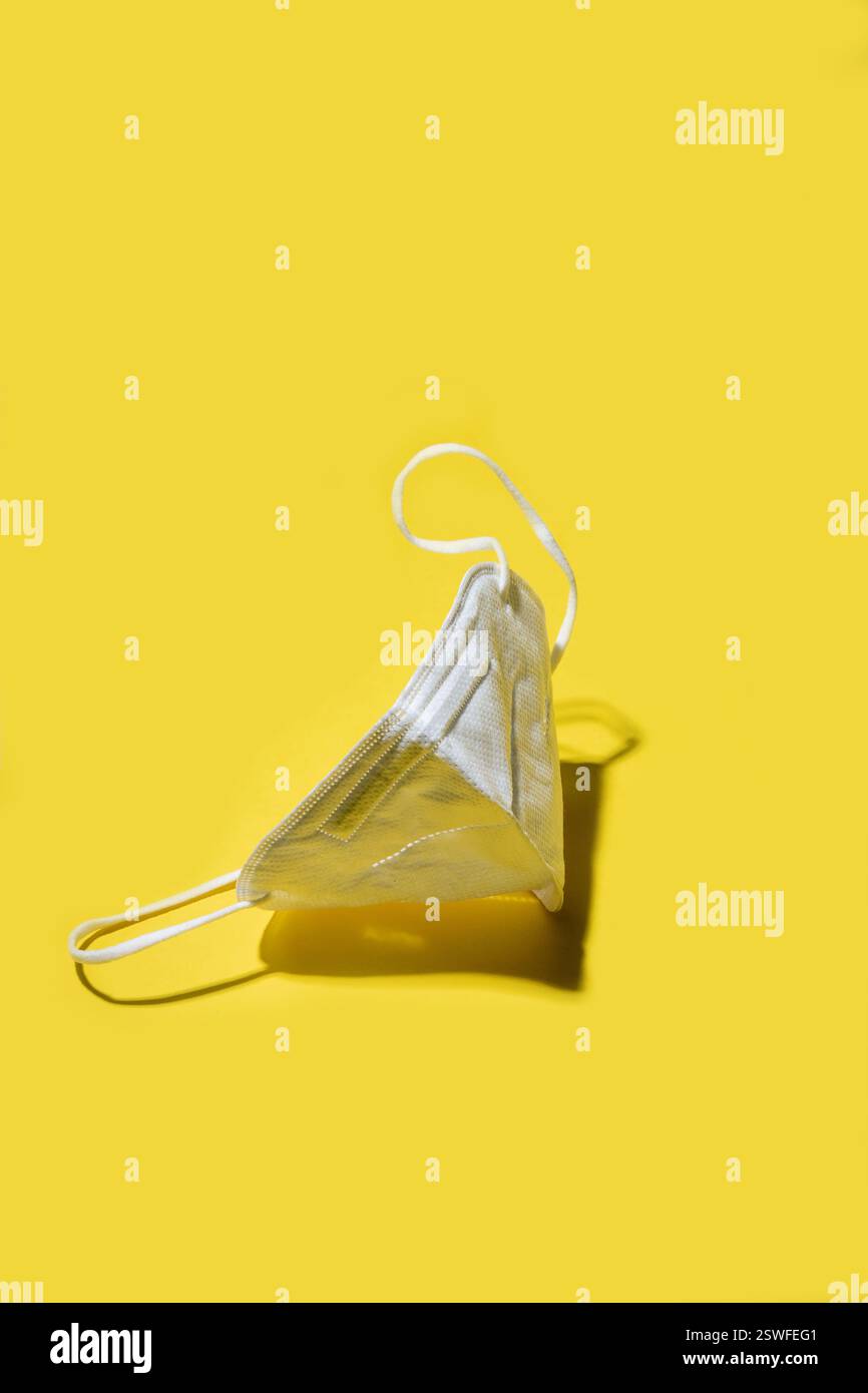 White medicine respirator KN95 mask over yellow Stock Photo - Alamy