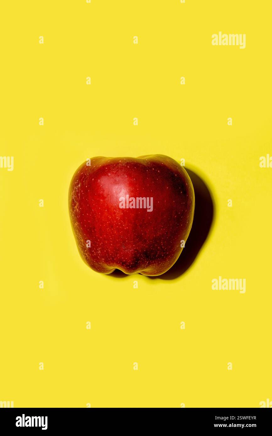 Red apple on a solid yellow background Stock Photo - Alamy