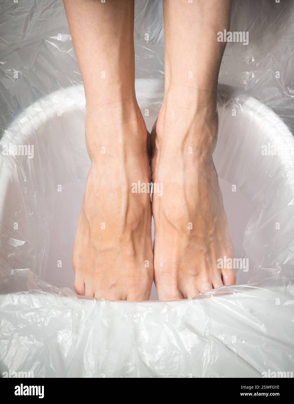Tired feet, Women's feet in a relaxing bath Stock Photo - Alamy