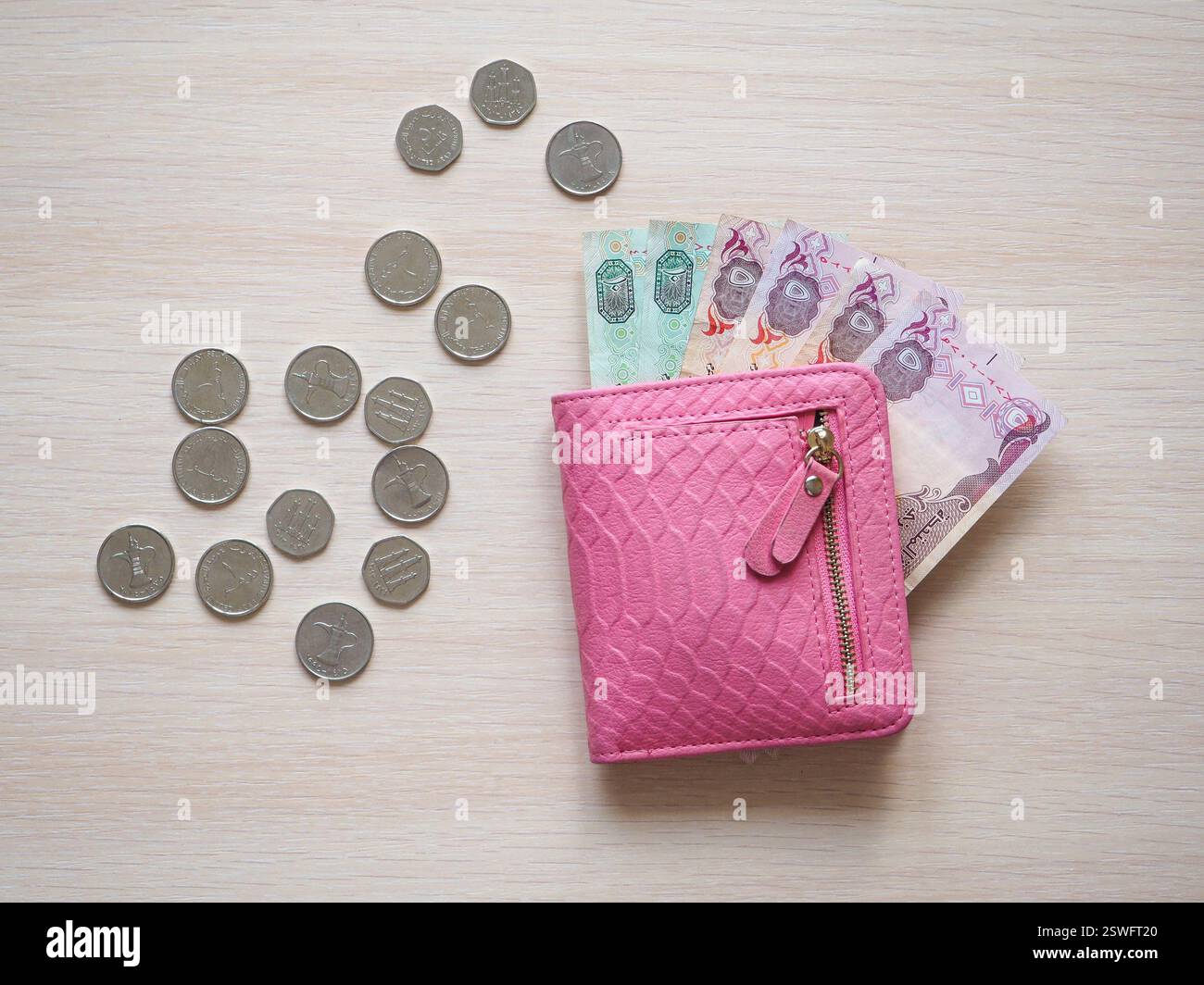Pink wallet with Arabic dirhams on the table. Top view Stock Photo - Alamy