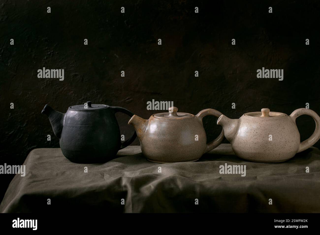 Set of craft handmade ceramic teapots with dark background Stock Photo ...