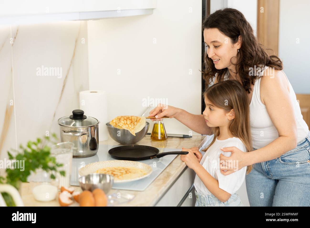 Mom and her daughter fry pancakes Stock Photo - Alamy