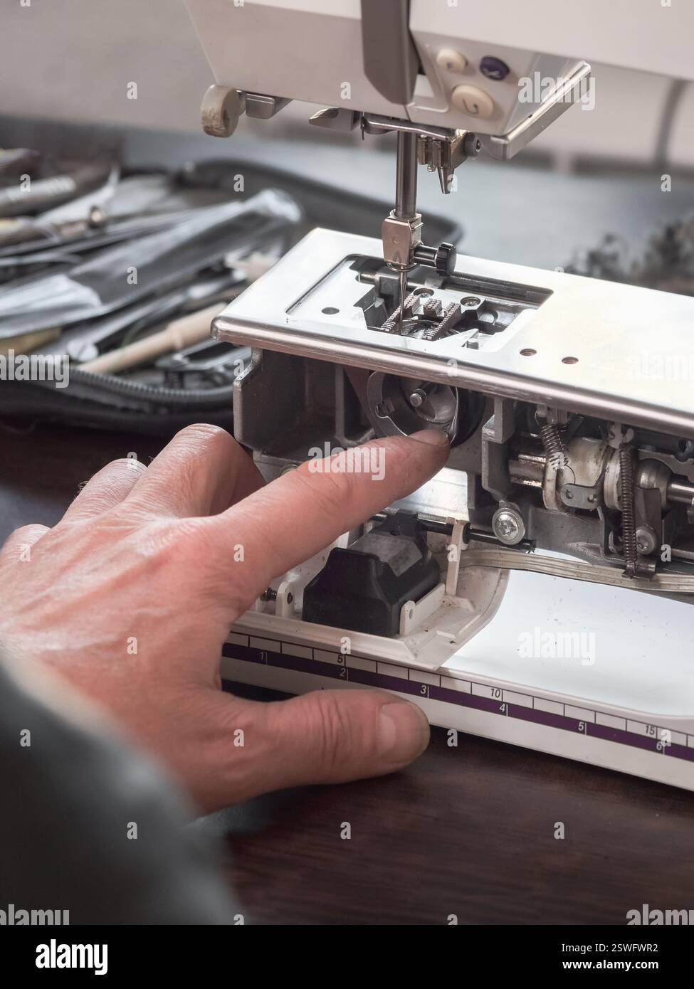 Finger of the sewing machine adjuster repairs the internal mechanism ...