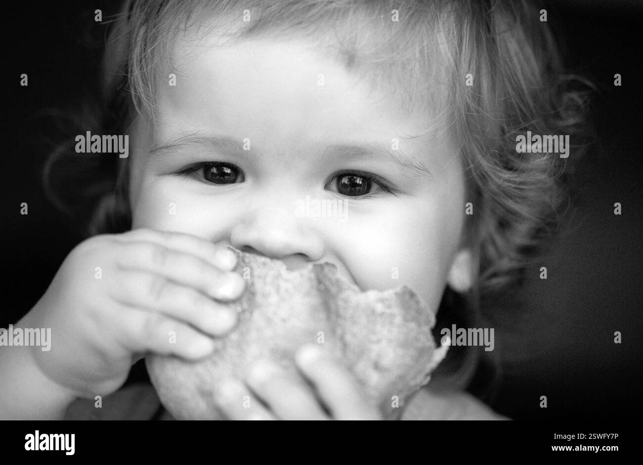 Baby eating bun bread. Close up face. Cute toddler child eating ...