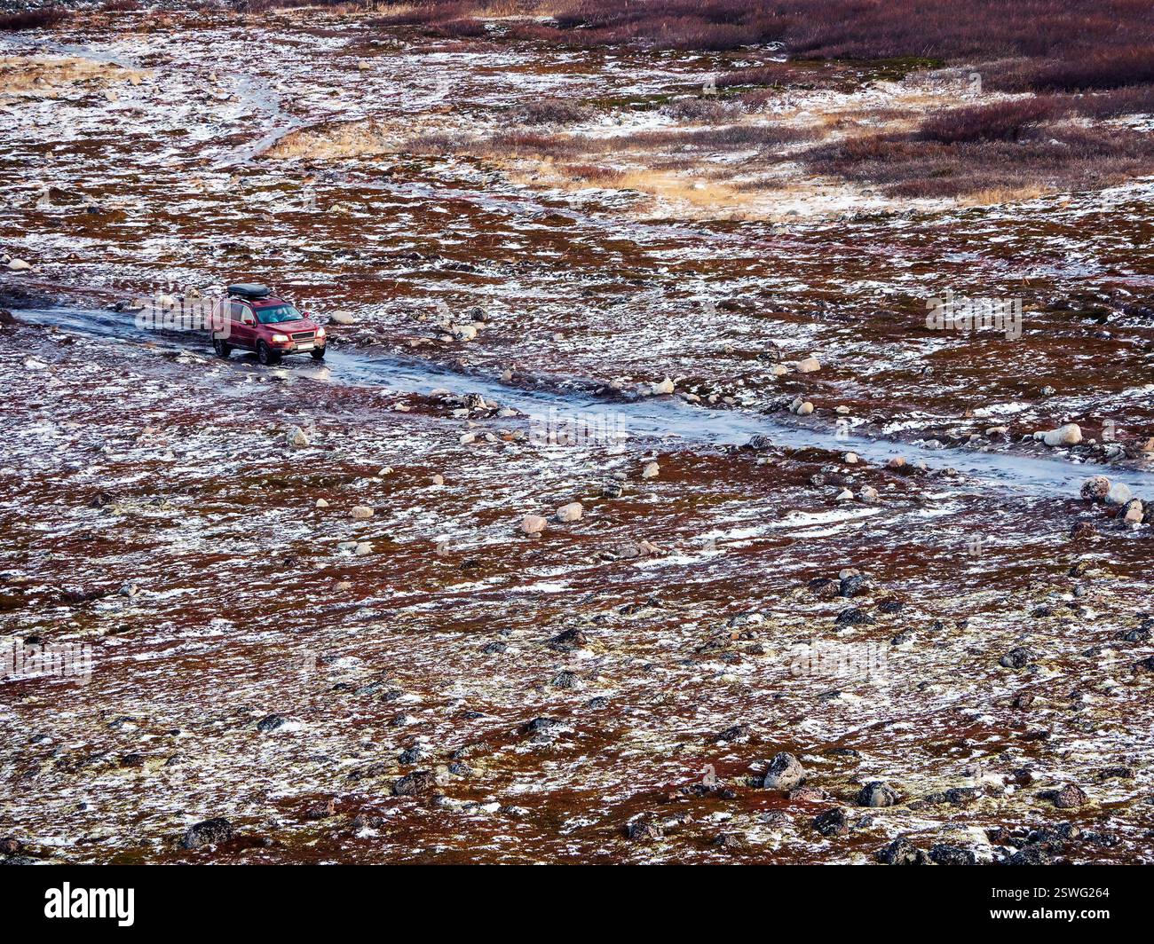 Icy slippery Arctic road through the tundra. Drop-off of tourists by ...